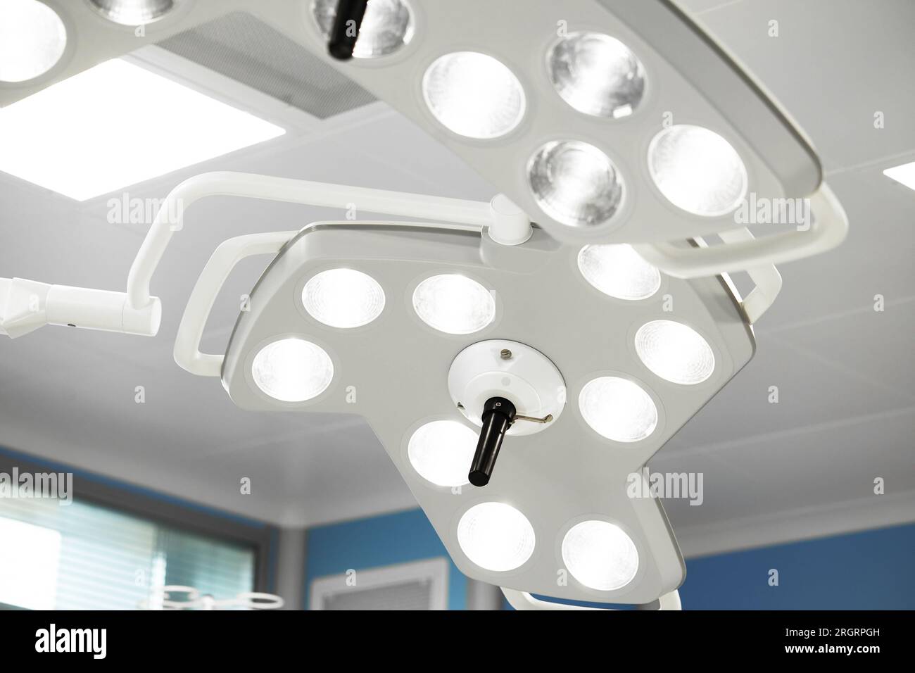 Two surgical lamps in operation room. Blue cast light represent purity ...