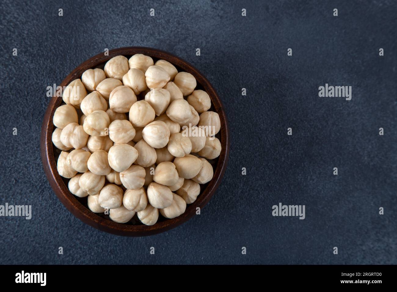 Top view of a bowl full of peeled hazelnuts on concrete background,top ...