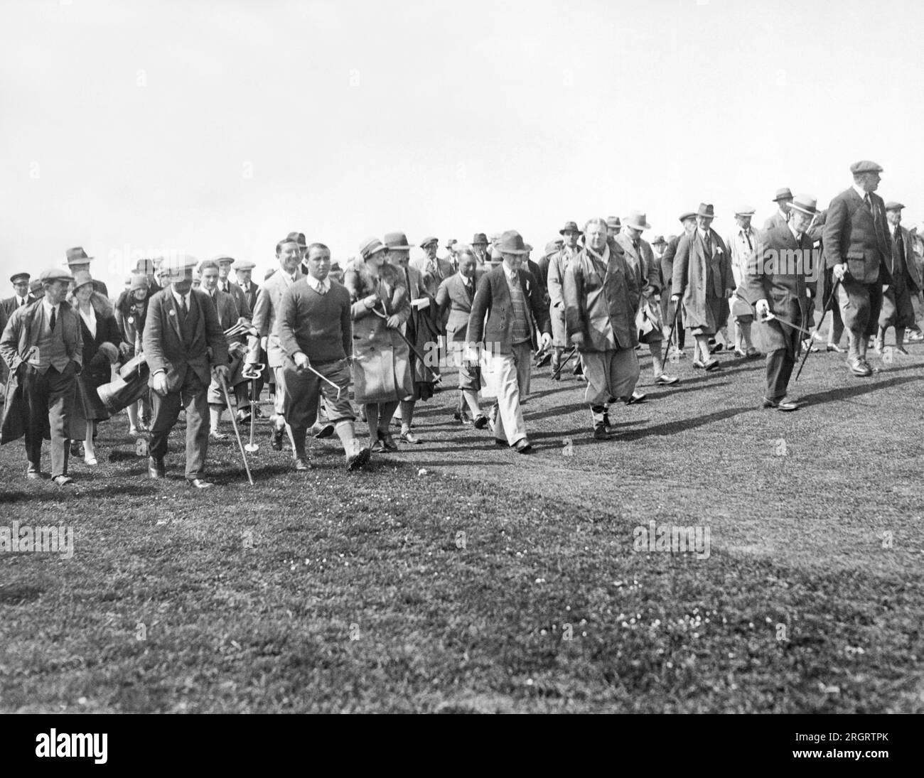 World: c. 1926 Bobby Jones walking on a golf course followed by his ...