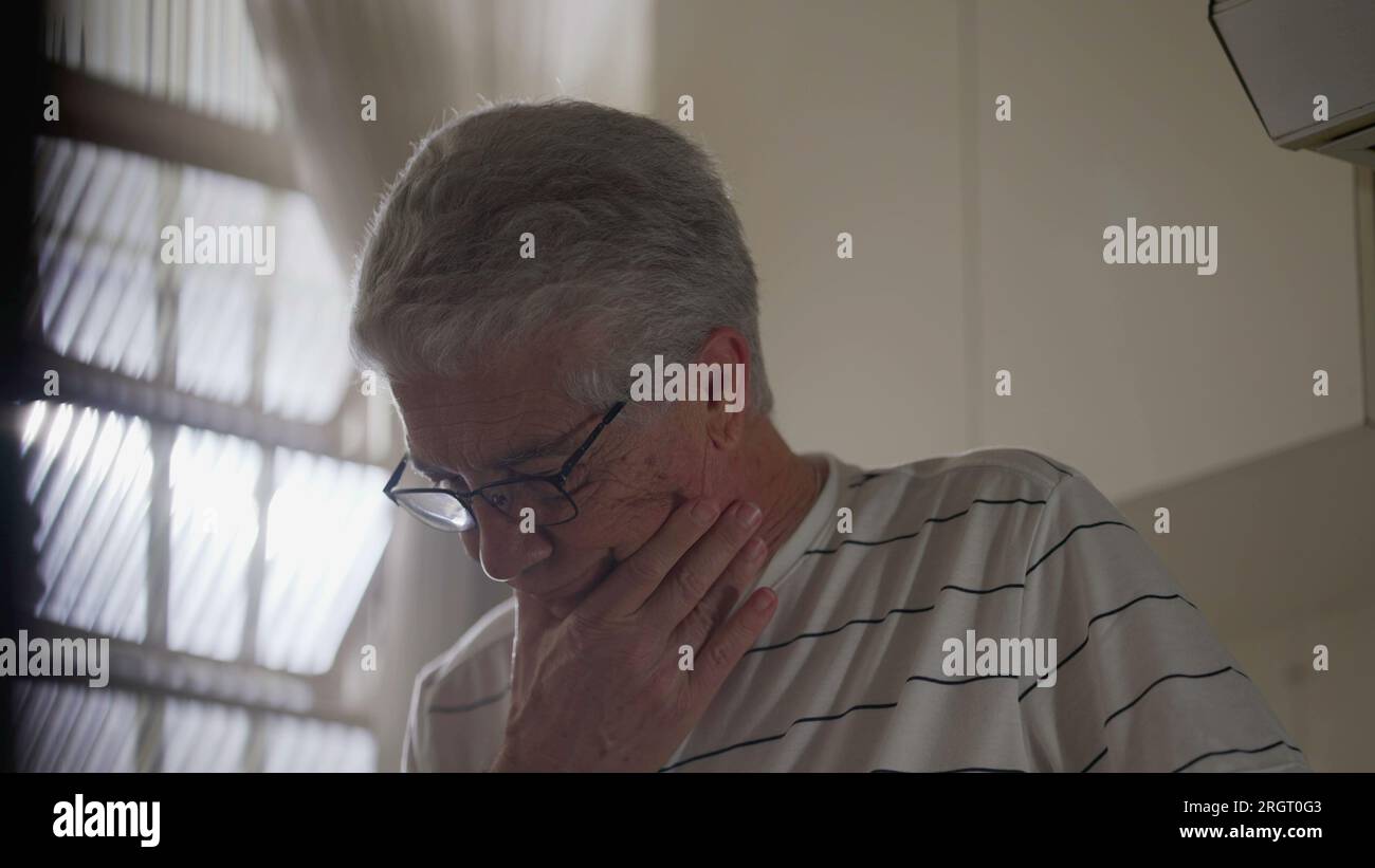 Anxious Older Man standing by window feeling worry. Regretful gray hair ...
