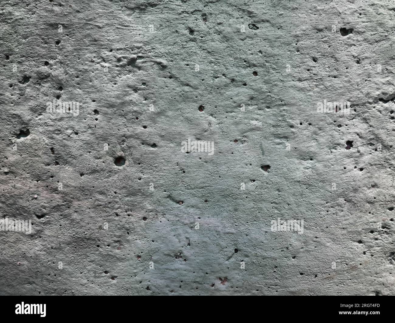 Texture of a light gray concrete wall with holes, strokes, granules ...