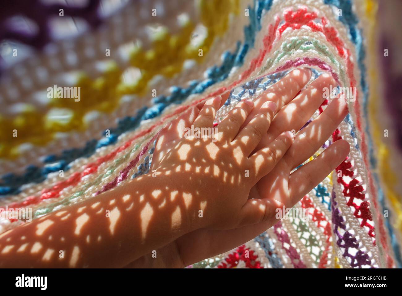 A child's hand in mom's hand under a blanket in bright sunlight Stock ...