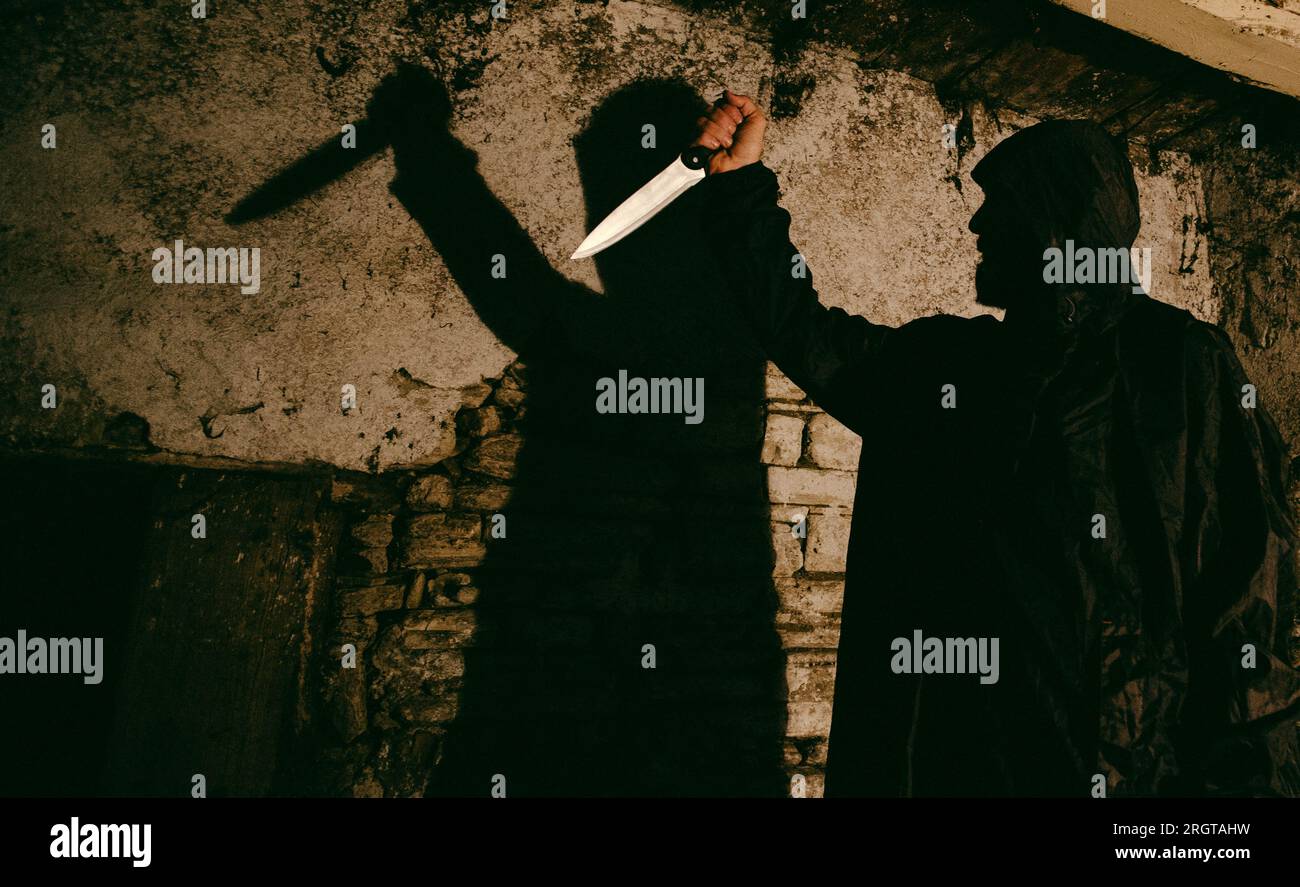 murderer with big knife and shadow horror scene Stock Photo - Alamy