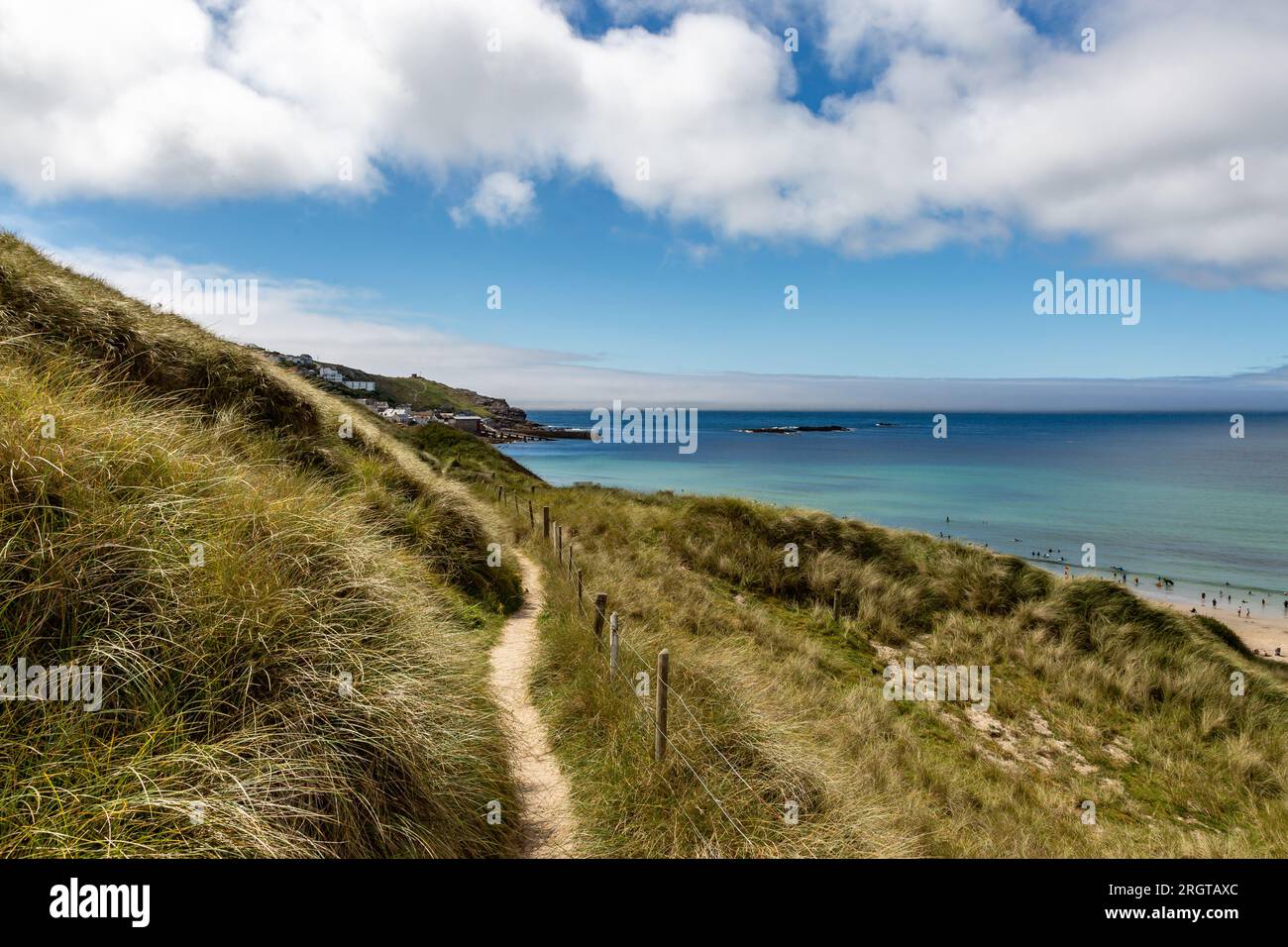 A coastal path above Sennen on the Cornish coast, with a blue sky ...