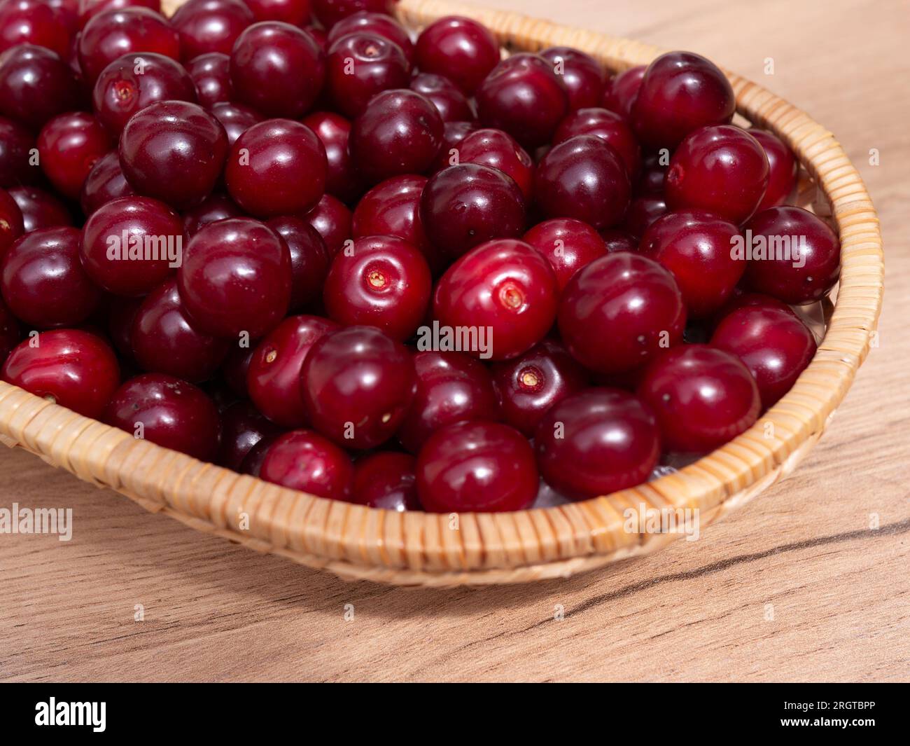 Large bowl of bright red cherries on a grey cement counter from above ...
