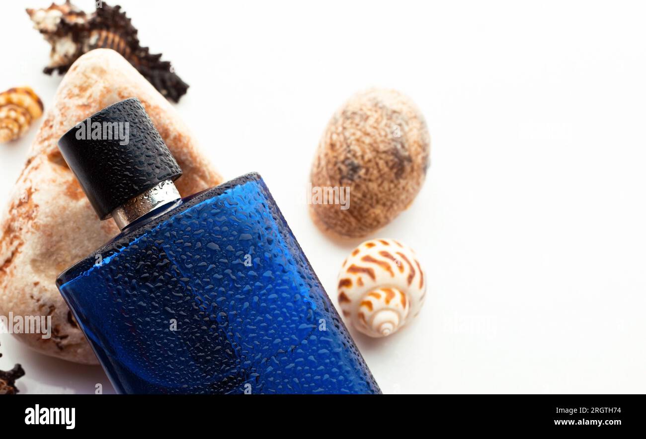 Perfume concept with sea notes. Frosted glass perfume bottle with sea ...