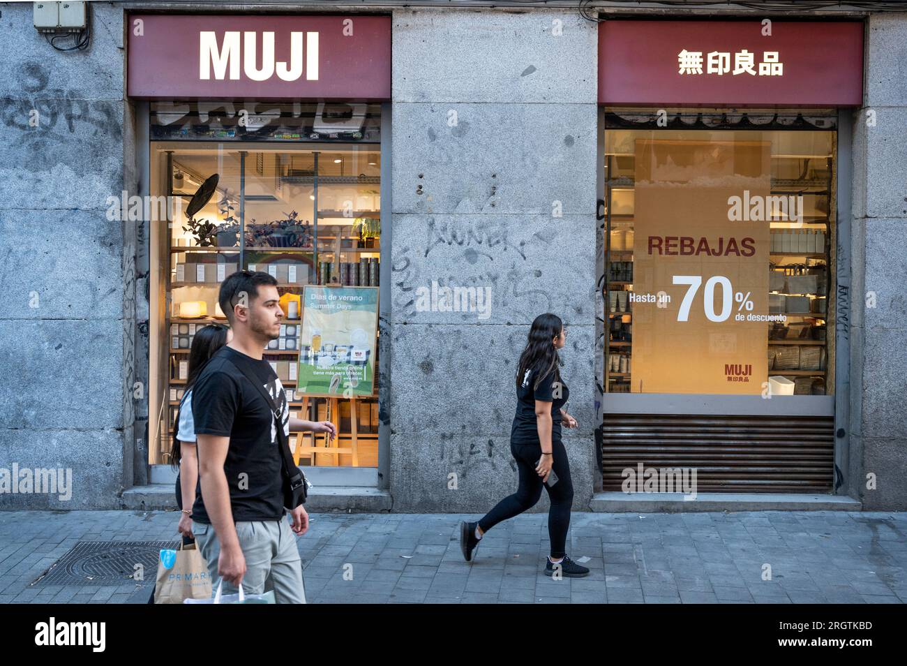 Pedestrians walk past the Japanese household and clothing retail ...