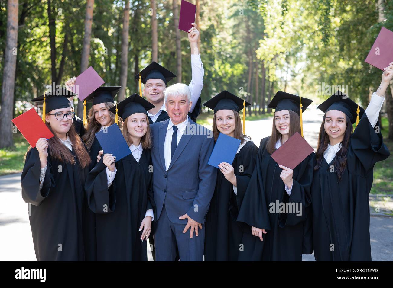 University professor and seven graduates rejoice at graduation Stock ...