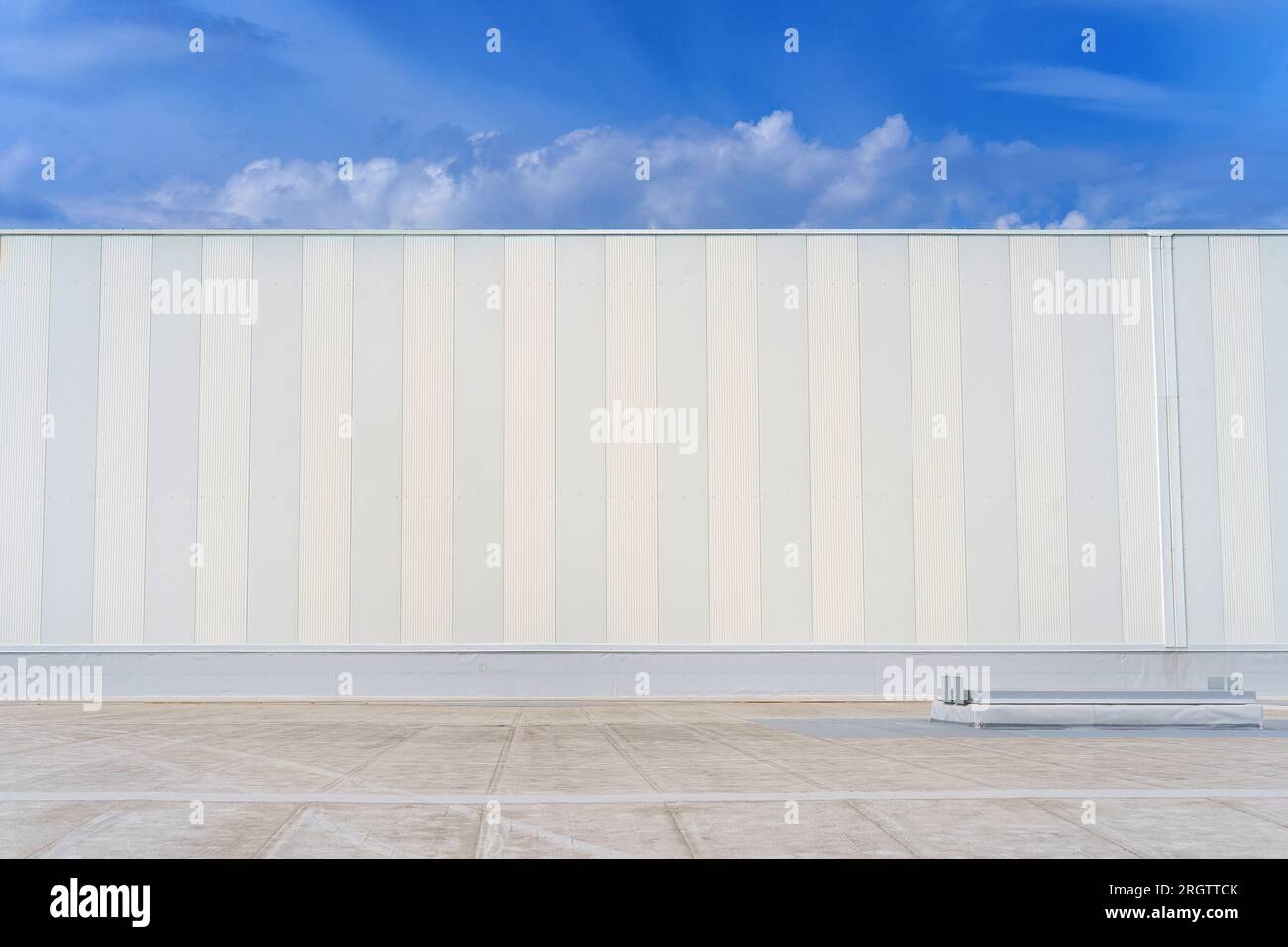 White metal sheet rooftop wall on commercial building with blue sky ...