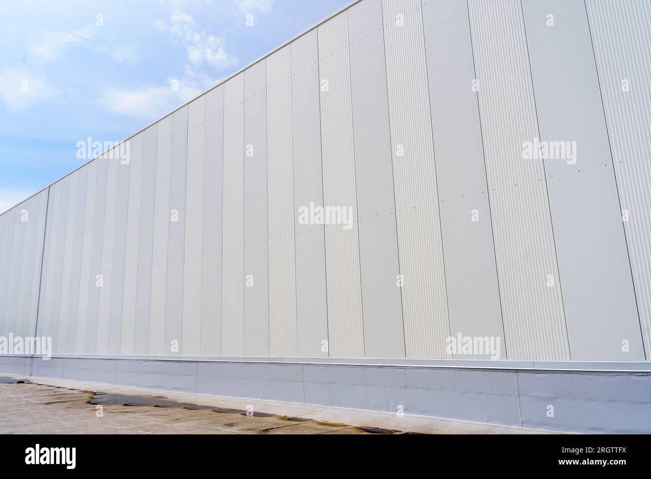 White metal sheet rooftop wall on commercial building with blue sky ...