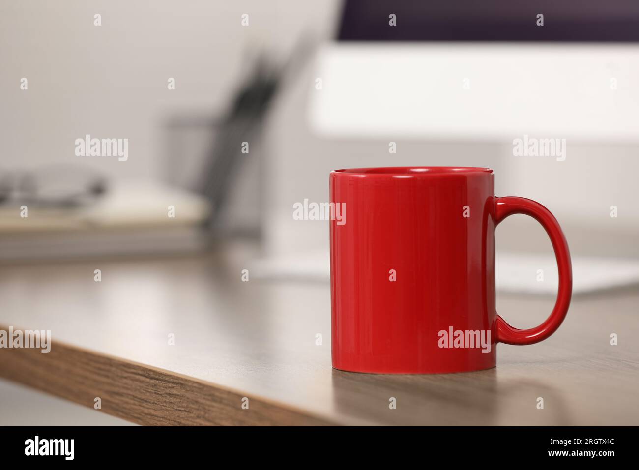 Red ceramic mug on wooden table at workplace. Space for text Stock ...