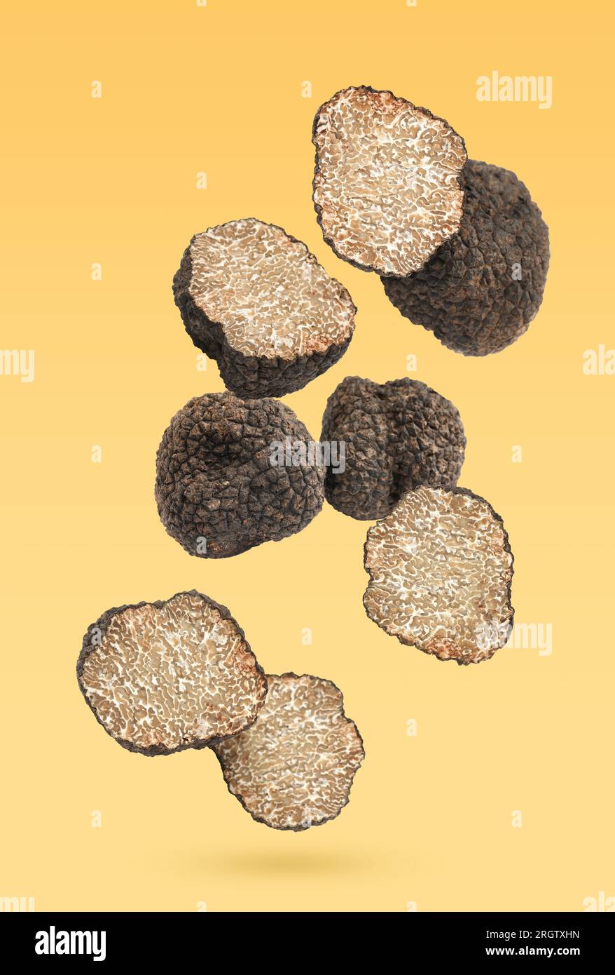 Cut and whole truffles falling on golden background Stock Photo - Alamy