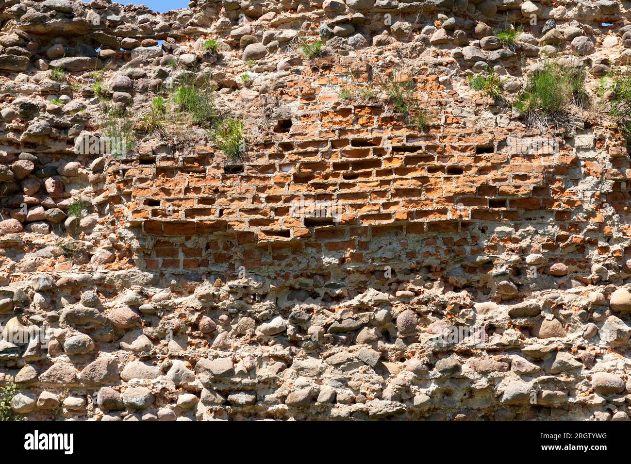 ruined and overgrown with grass ruins of an ancient fortress and stones ...