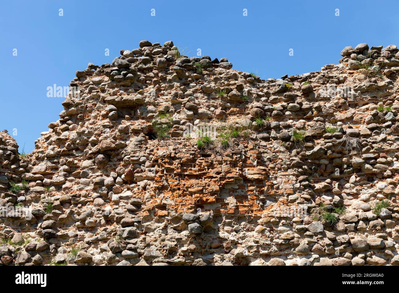 ruined and overgrown with grass ruins of an ancient fortress and stones ...