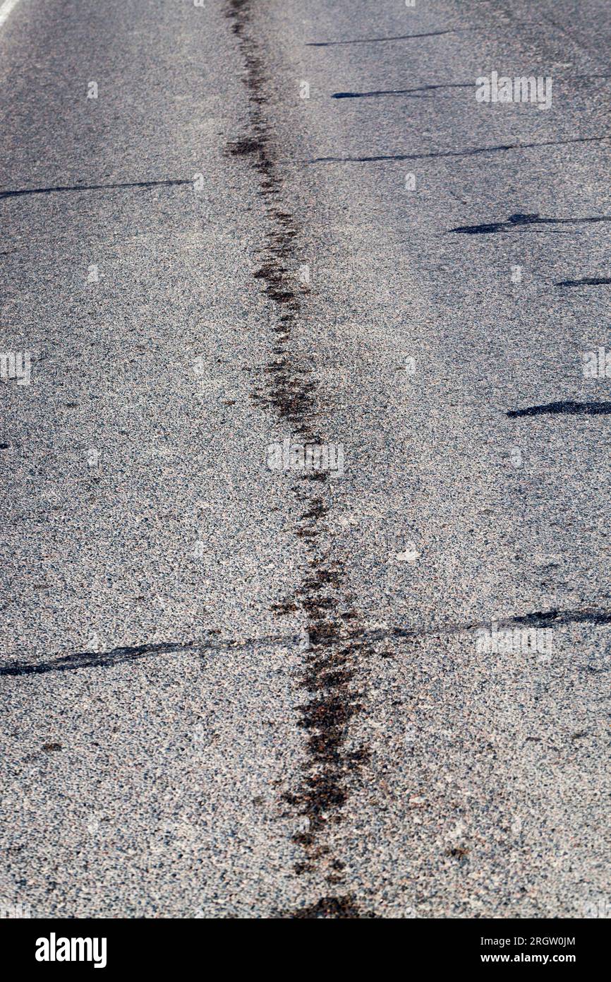 traces of road repairs, part of an asphalt road with damage and stains ...
