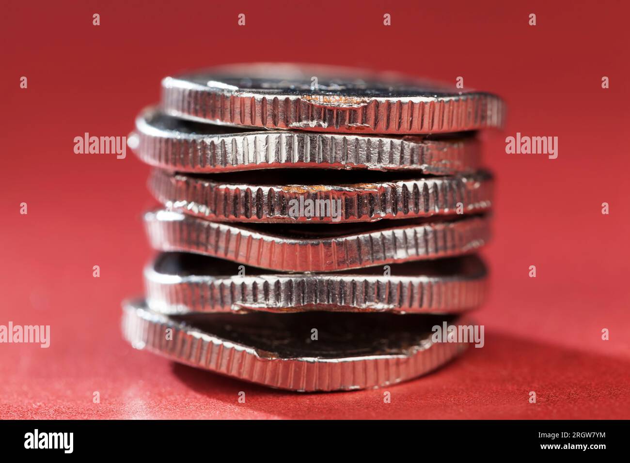 broken bent and rusting metal coins on a red background Stock Photo - Alamy
