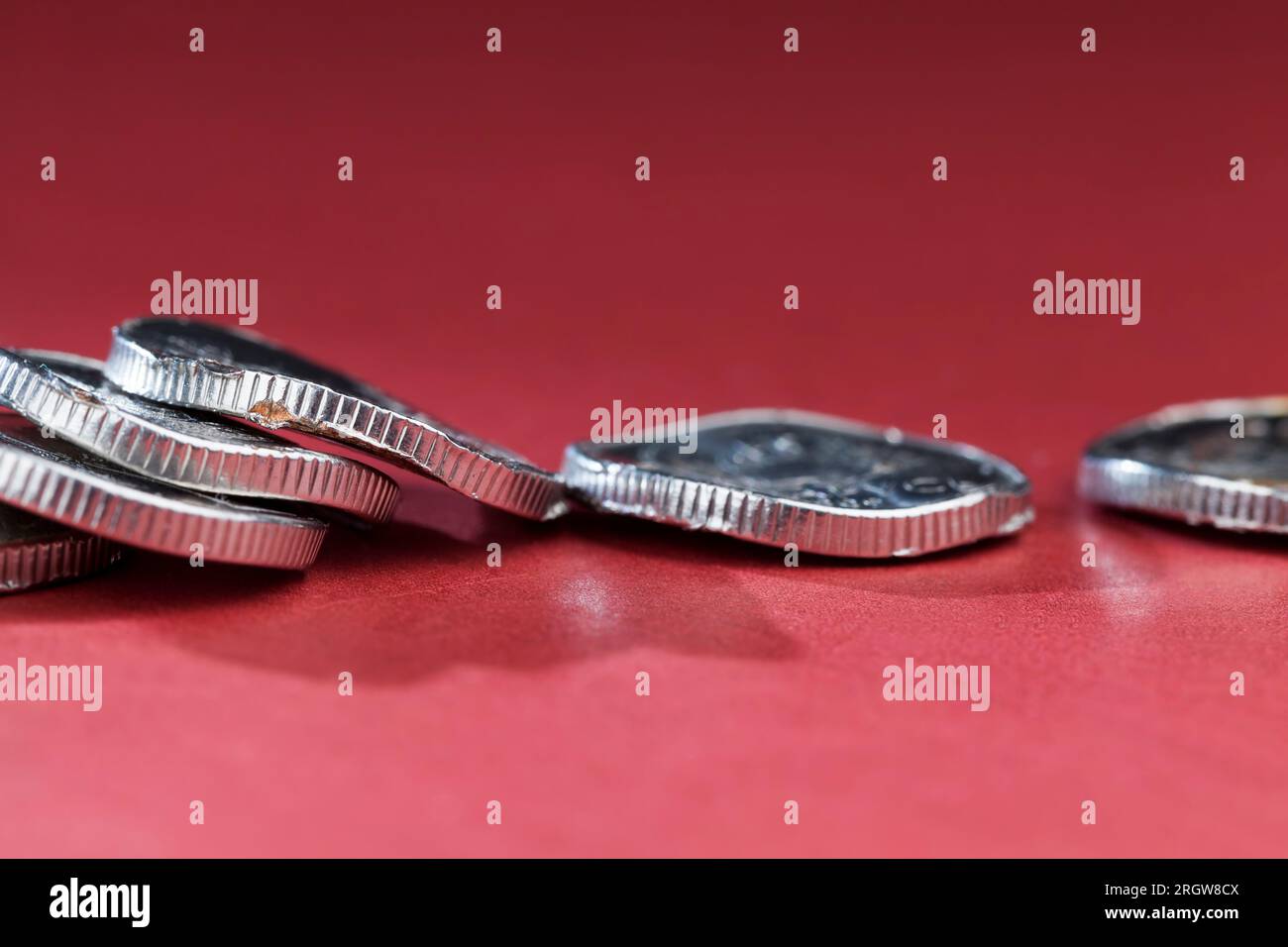 broken bent and rusting metal coins on a red background Stock Photo - Alamy