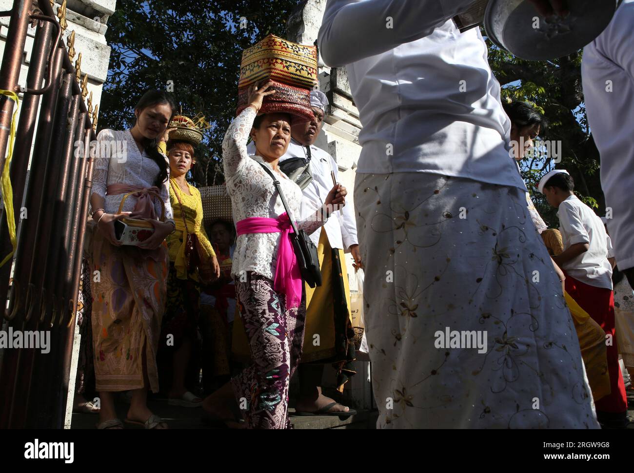 People carry their offerings to celebrate the Kuningan festival at a ...