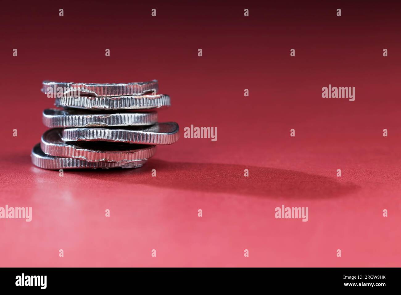 broken bent and rusting metal coins on a red background Stock Photo - Alamy