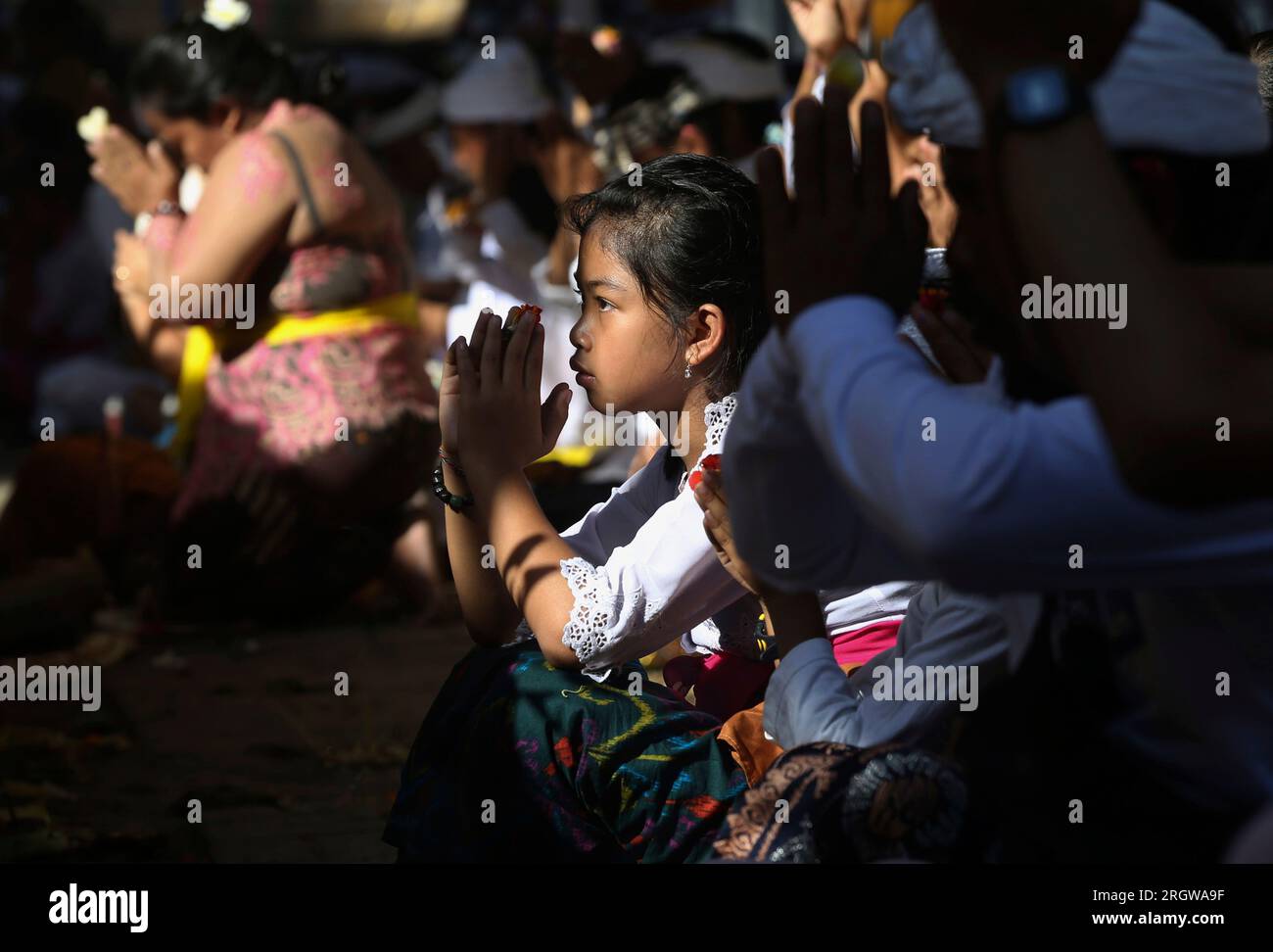 A girl prays to celebrate the Kuningan festival at a Hindu temple in ...