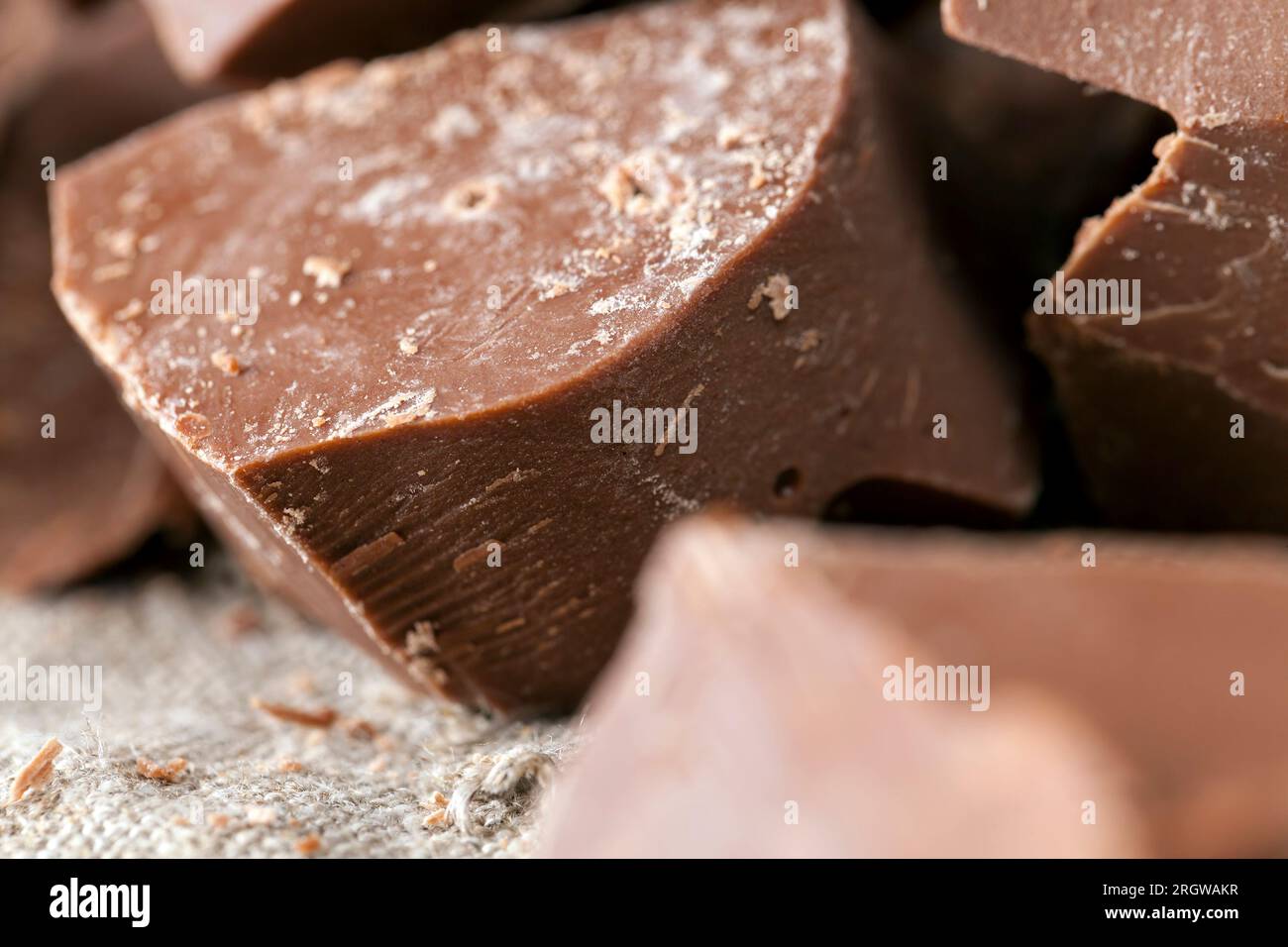 pieces of bitter chocolate are randomly scattered on the table, broken ...