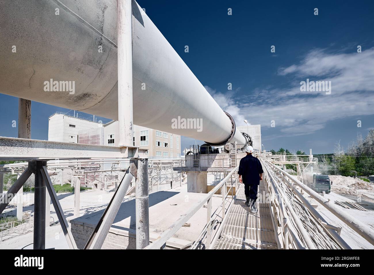 Worker walks along ladders for maintenance of rotary kiln Stock Photo ...