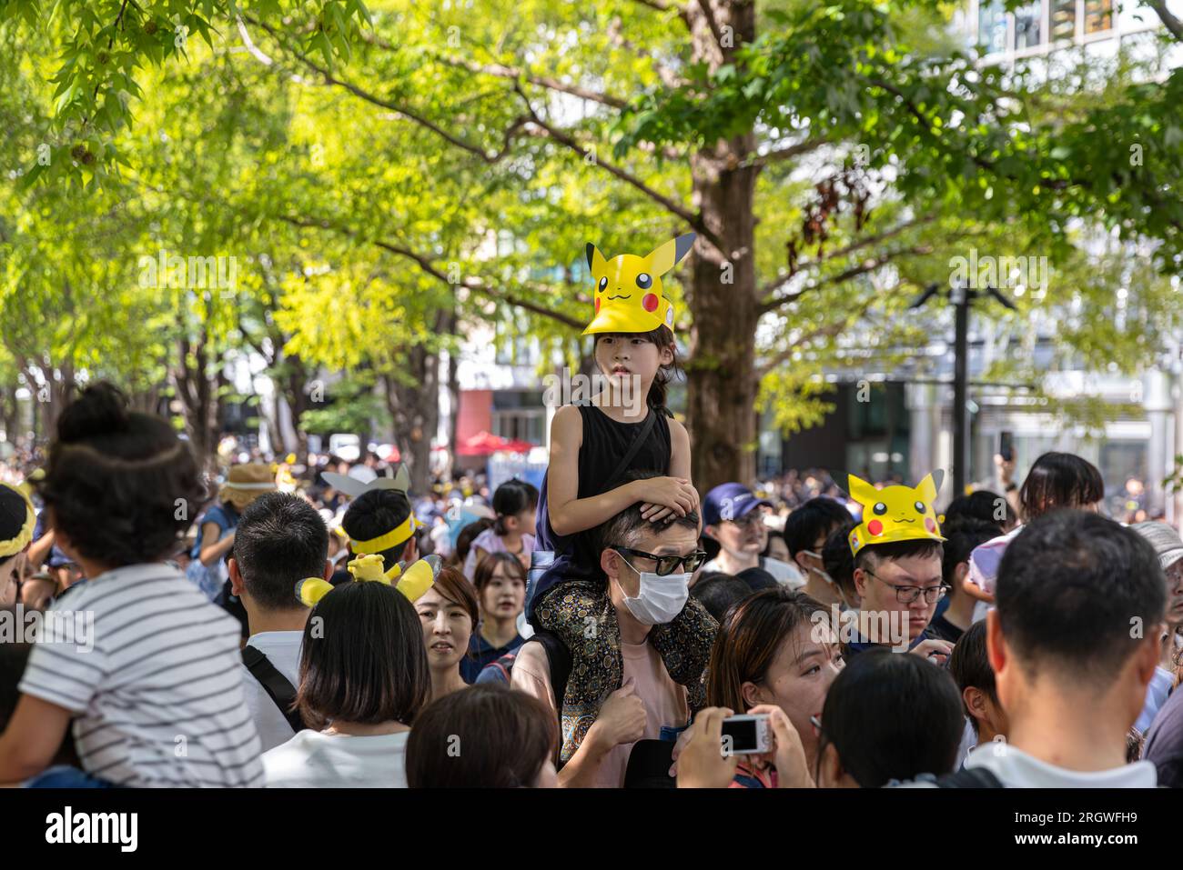 Yokohama, Japan. 11th Aug, 2023. Girl with Pikachu themed cap is carried on her father's ...