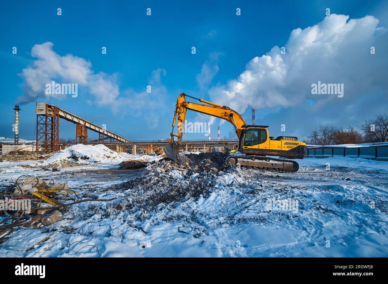 Bucket on excavator digs pit removing debris on winter day Stock Photo ...