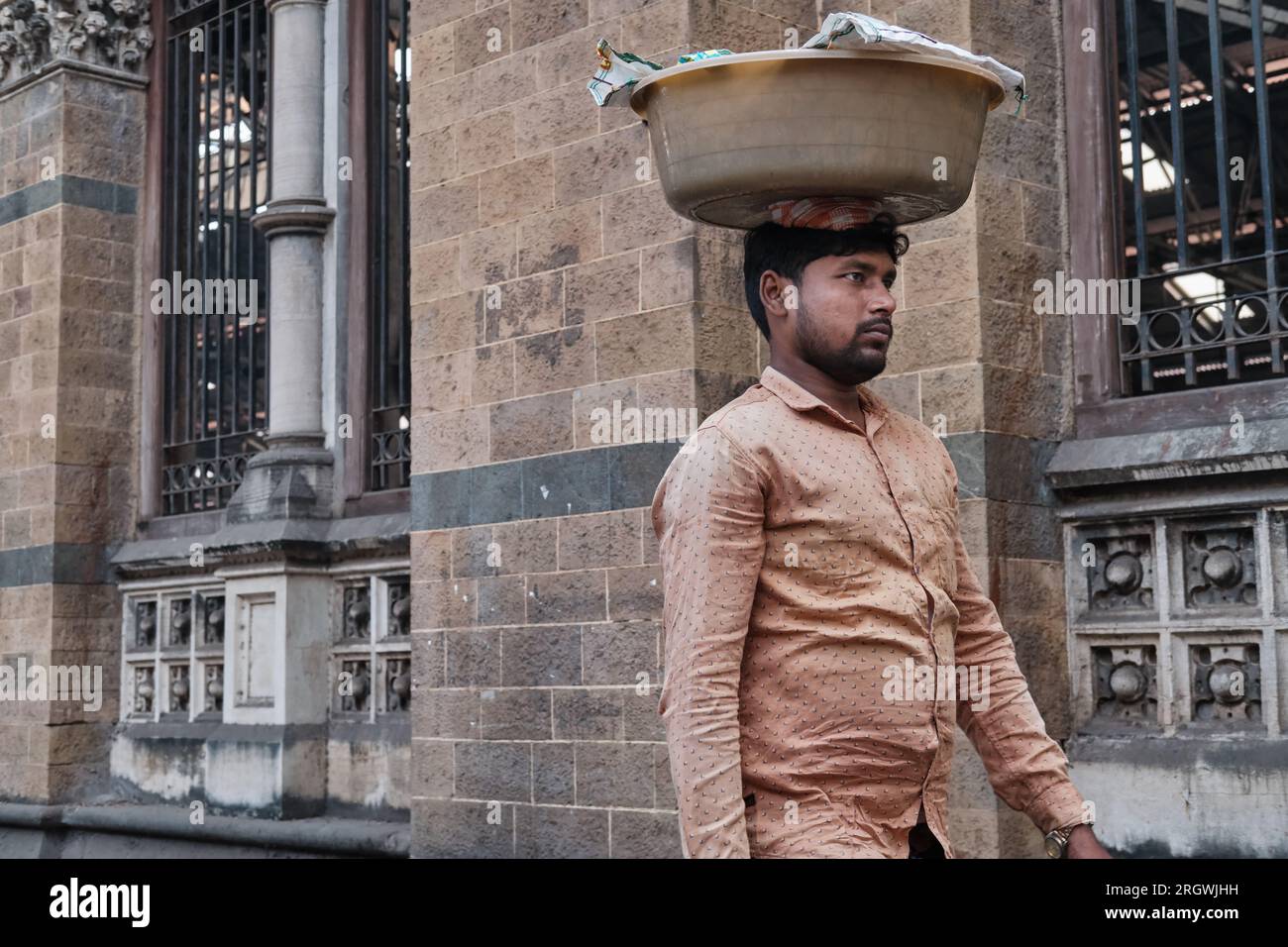 A porter with a tray of fish on his head, outside Chhatrapati Shivaji ...