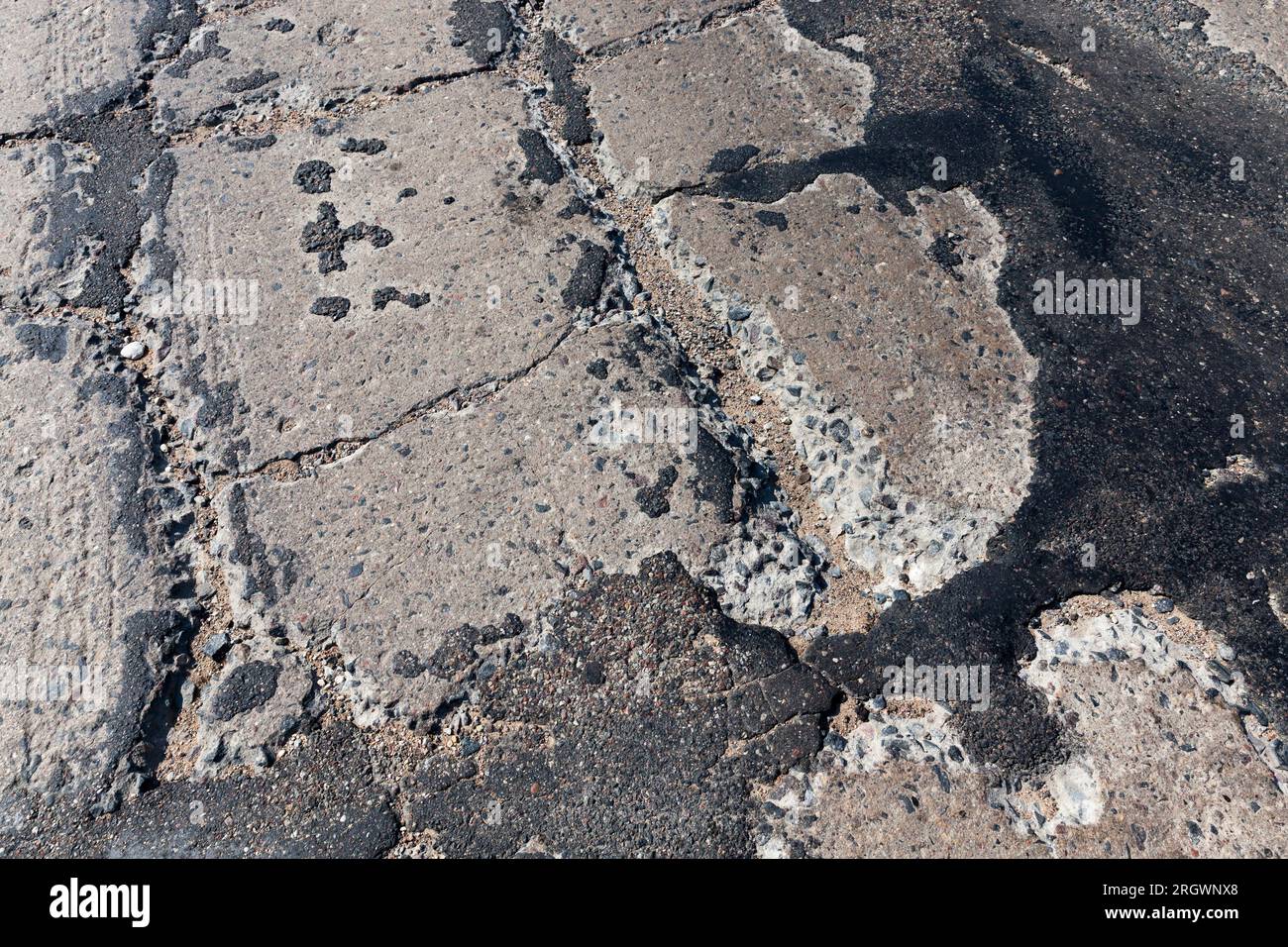 a bad road with poorly repaired potholes and pits, a road of poor ...