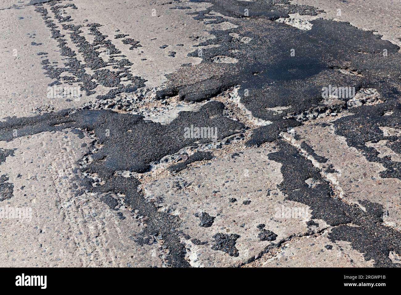 a bad road with poorly repaired potholes and pits, a road of poor ...