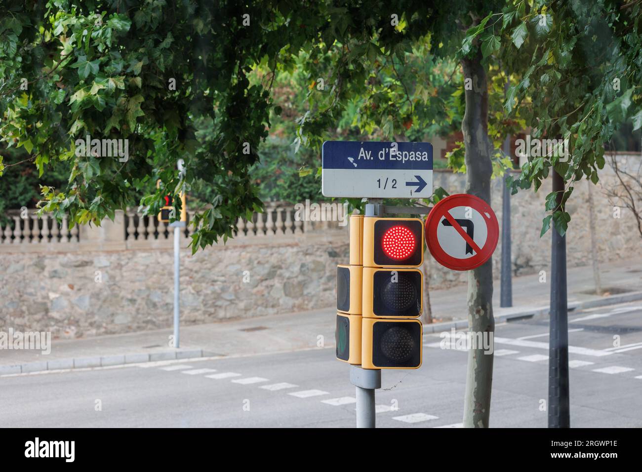 Traffic Light on Red and Street Sign displaying d’Espasa Street in ...