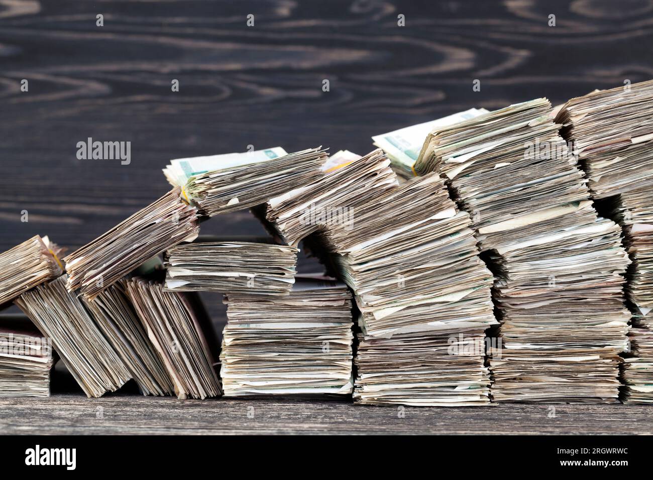 a large amount of old crumpled and dirty money, stacked in huge piles ...