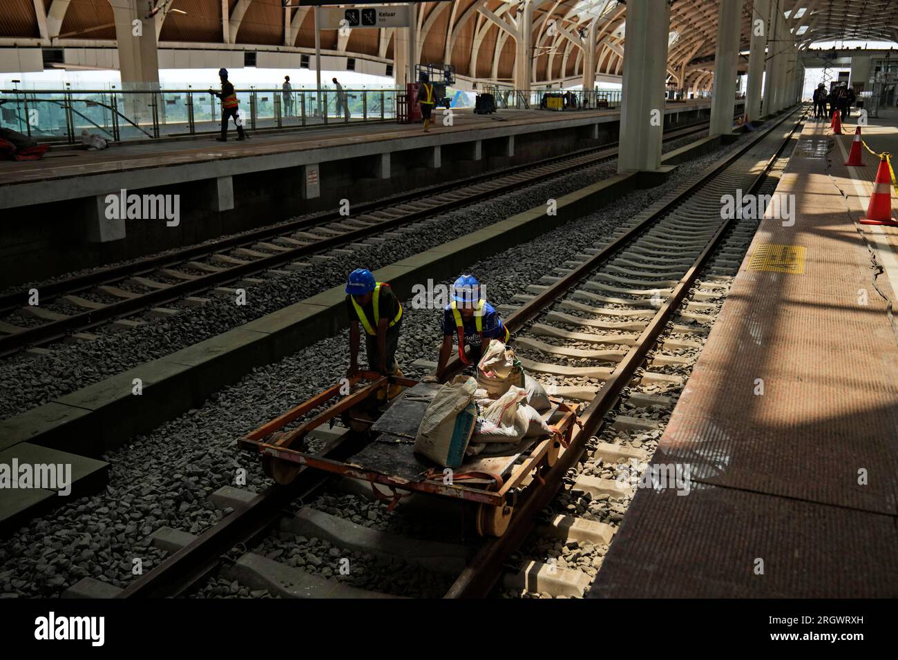 Workers use a cart to transport building materials at the construction ...