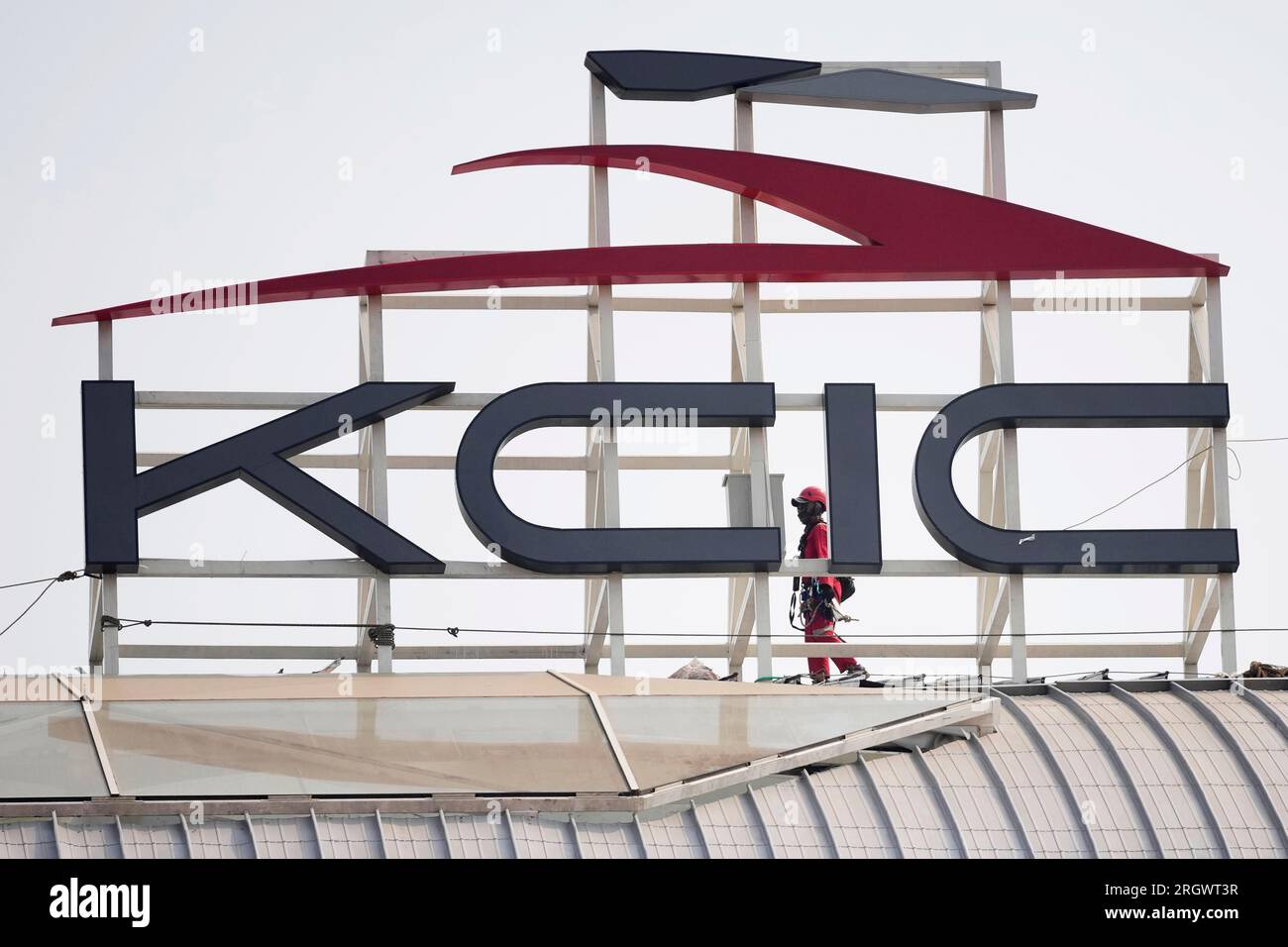 A worker walks past the logo of PT Kereta Cepat Indonesia-China (PT ...