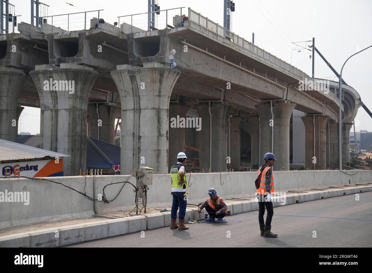 Workers use a measuring line at the construction site of Halim Station ...