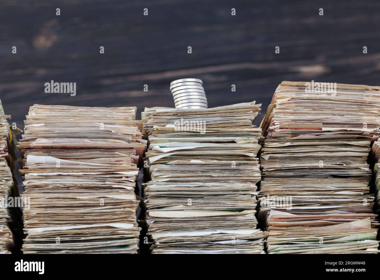 a large amount of old crumpled and dirty money, stacked in huge piles ...