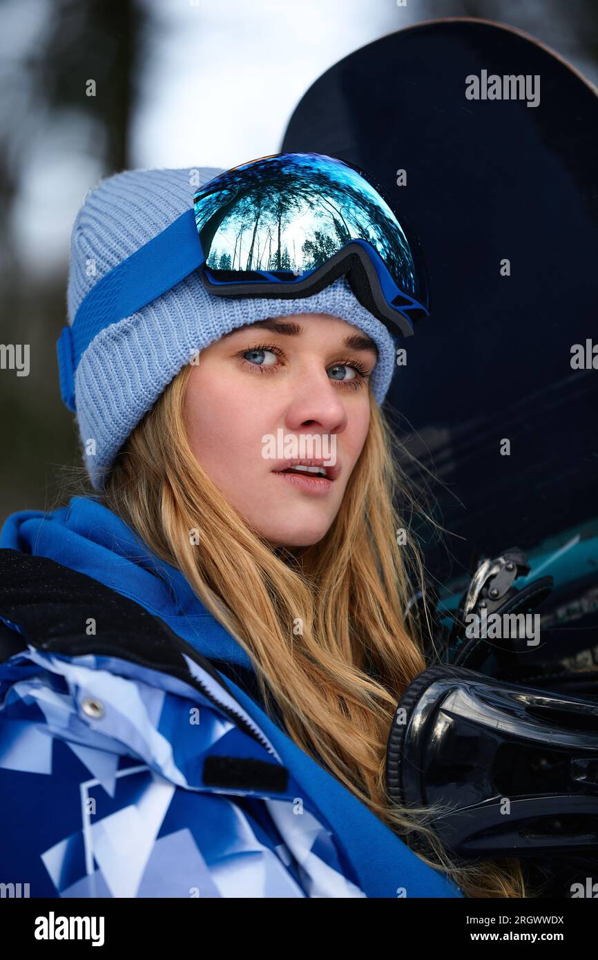 image with a portrait of a female snowboarder wearing a helmet with a bright reflection in the ...