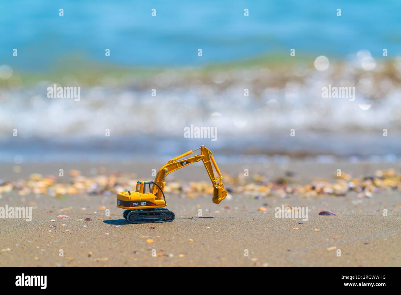 Caterpillar model excavator on sandy sea shore Stock Photo - Alamy