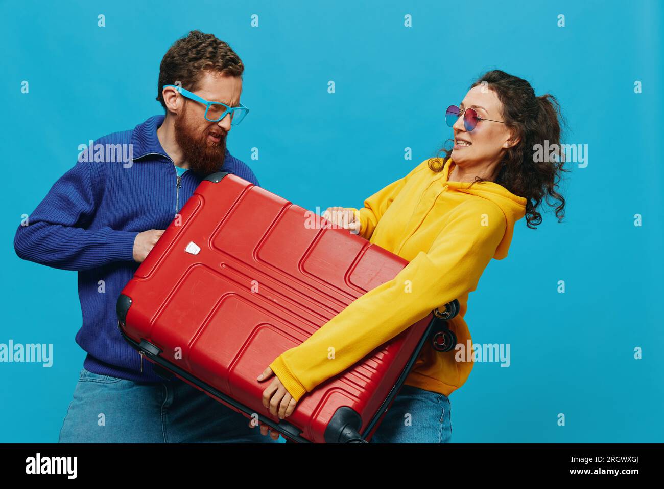 Woman and man smile suitcases in hand with yellow and red suitcase ...