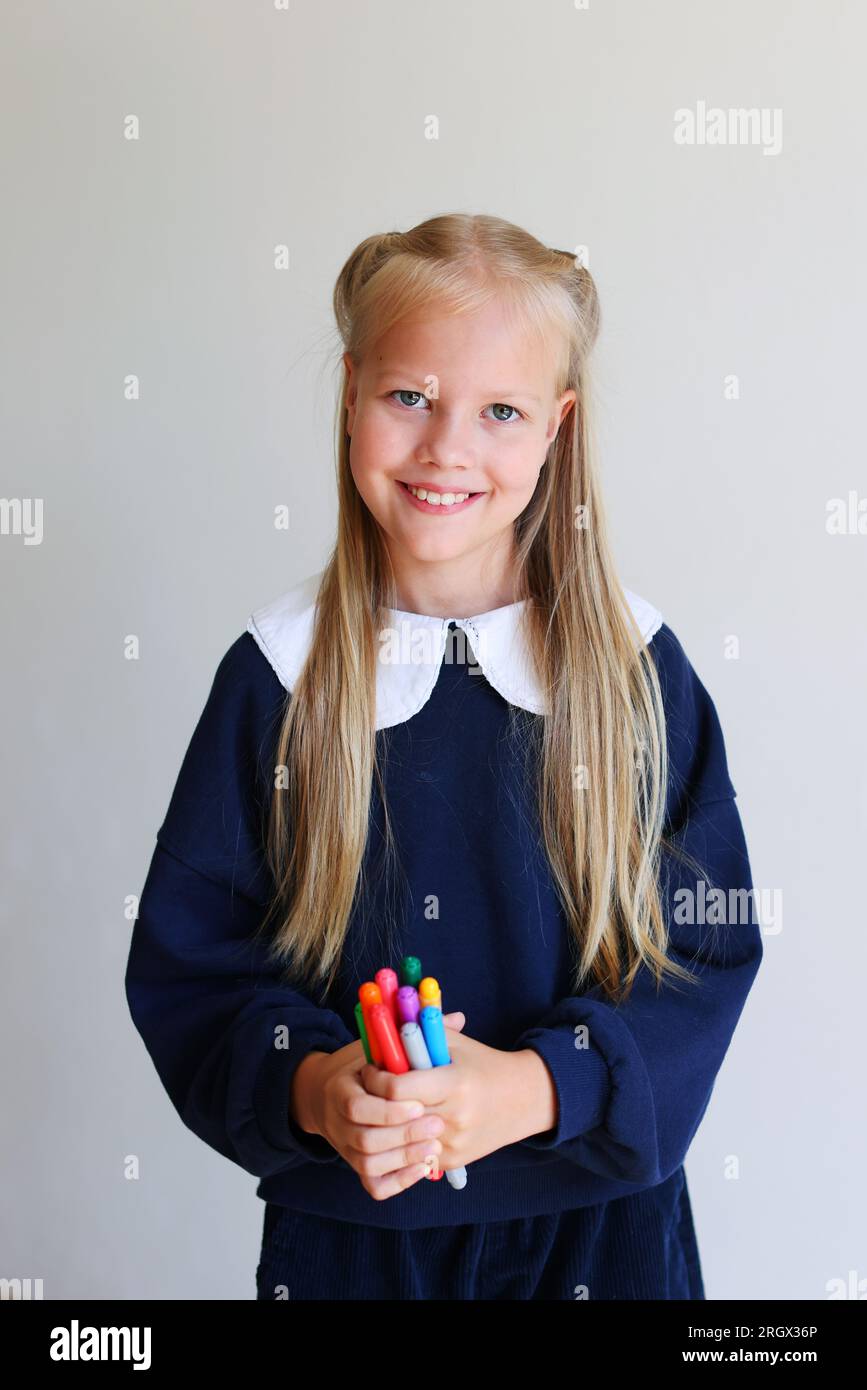 Beautiful cute school girl with glasses holding colorful pencils. Sulky ...