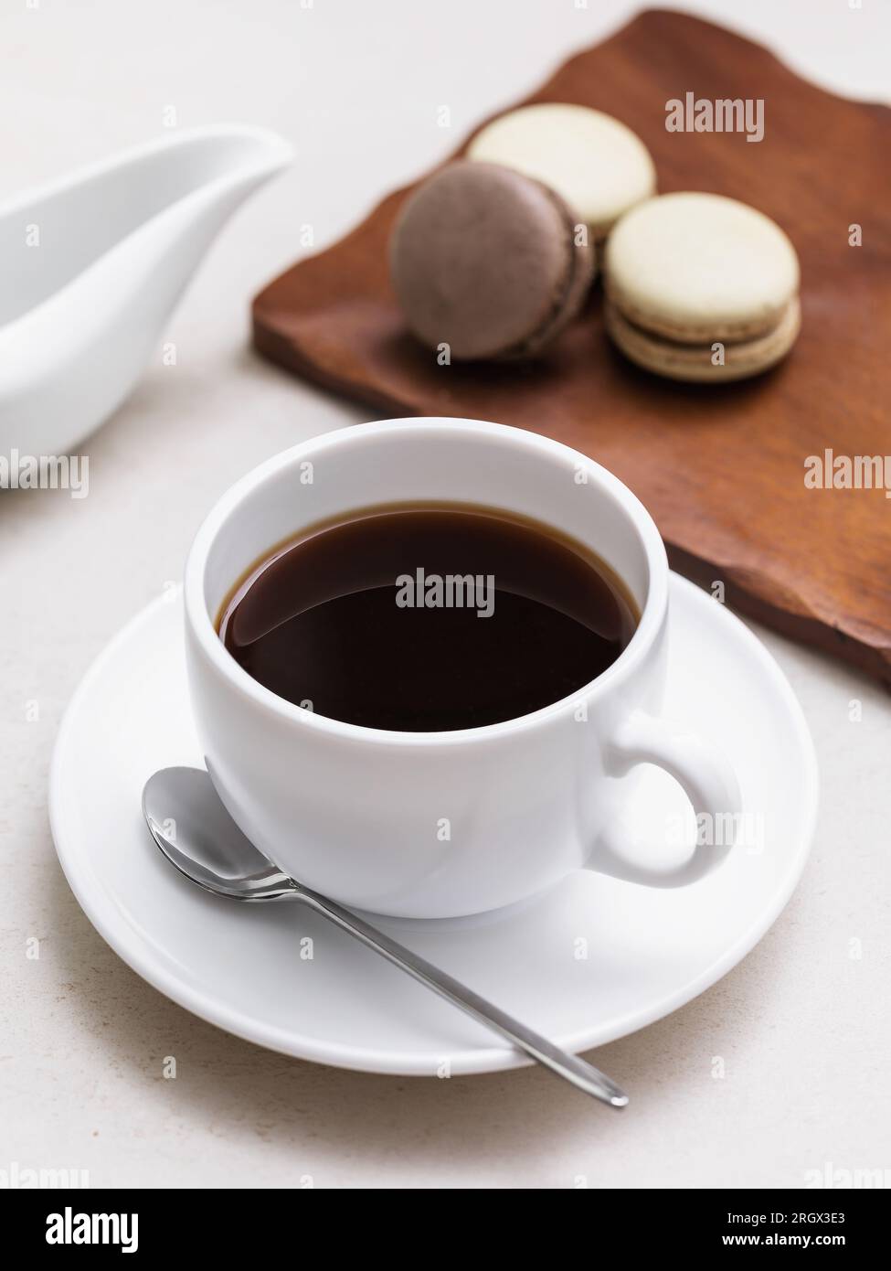 Coffee in a white ceramic cup with macaroons on the table Stock Photo ...