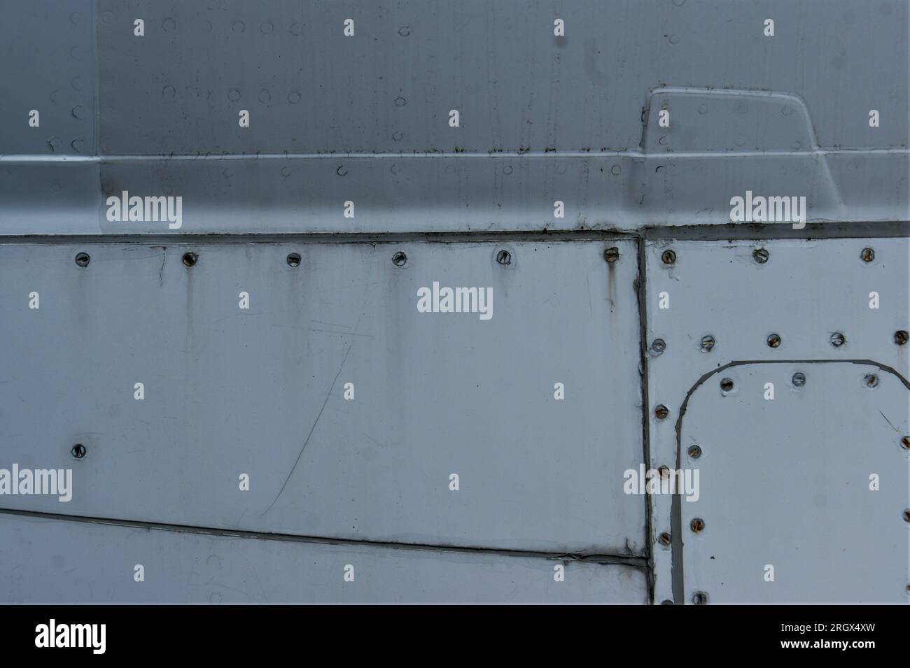 Fragment of an old airplane fuselage. Metallic background with screws ...