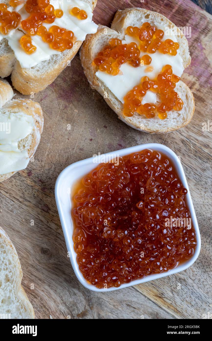 natural red salmon caviar with baguette and butter, making sandwiches ...