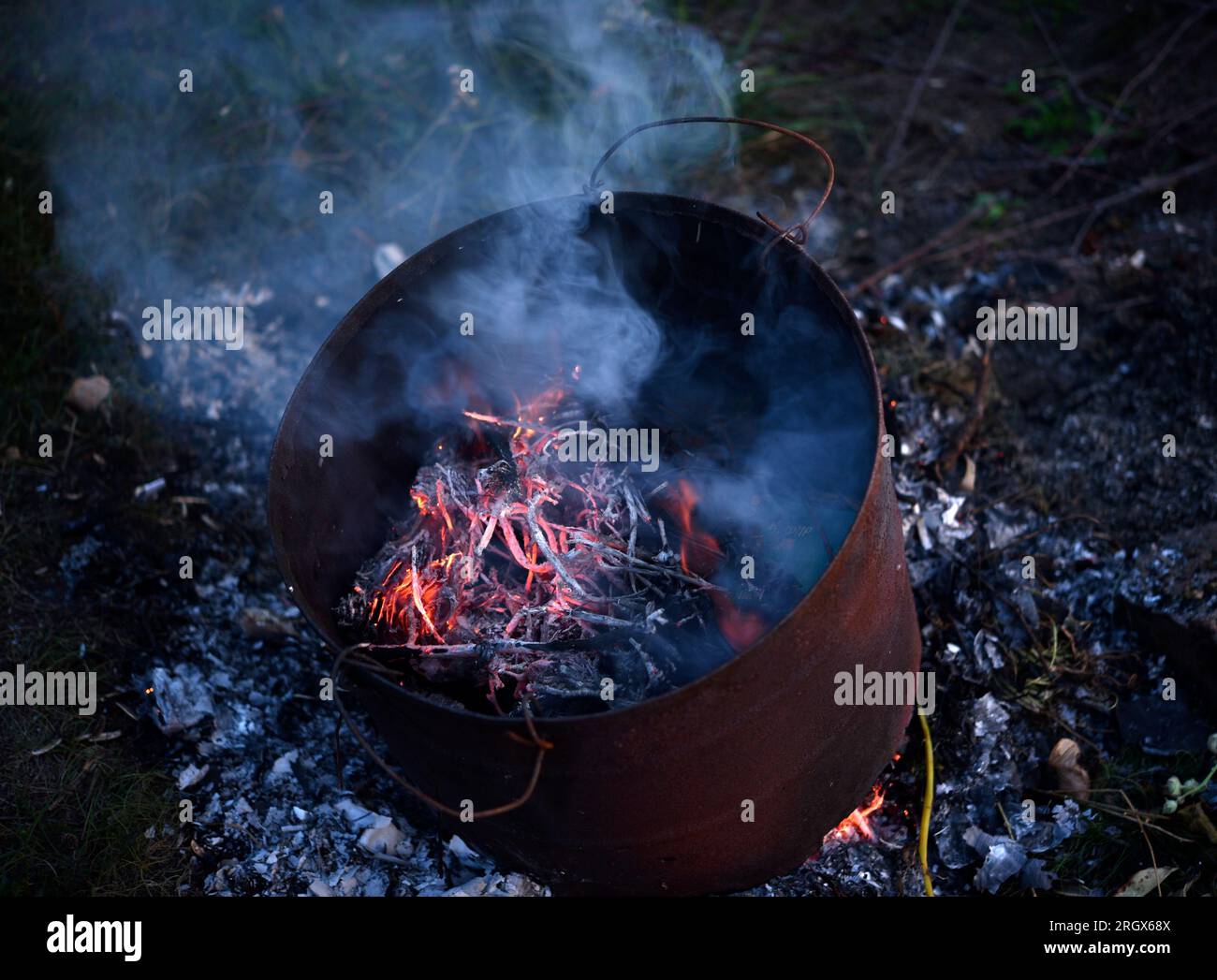 Burning garbage in the tank. Incineration of garbage in an iron bucket ...