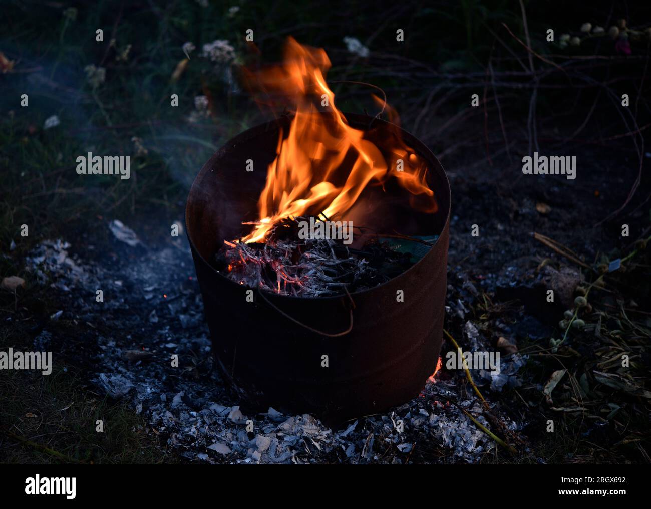 Burning garbage in the tank. Incineration of garbage in an iron bucket ...