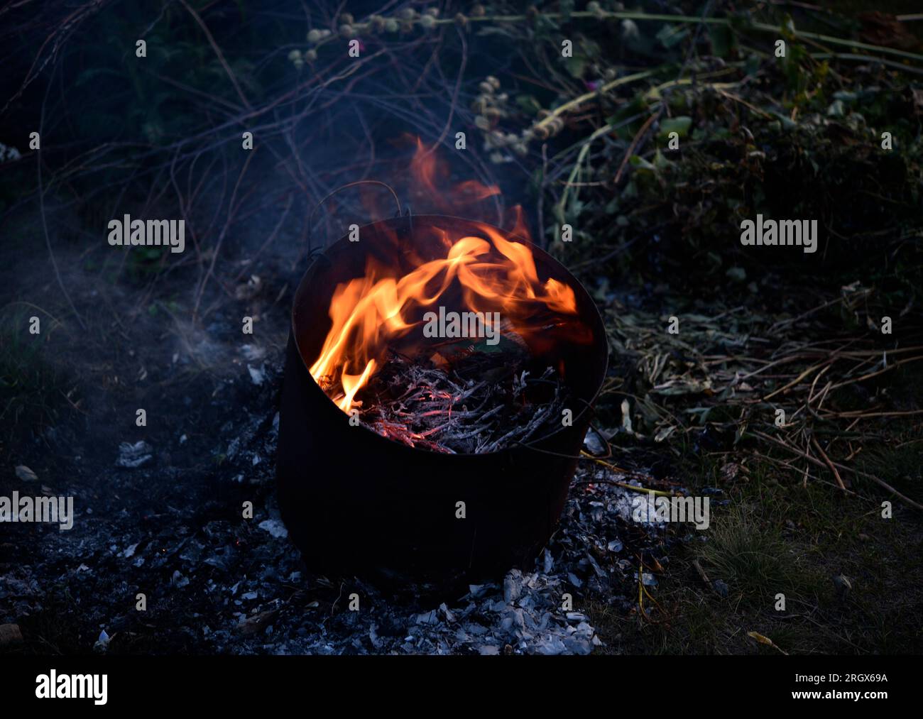 Burning garbage in the tank. Incineration of garbage in an iron bucket ...
