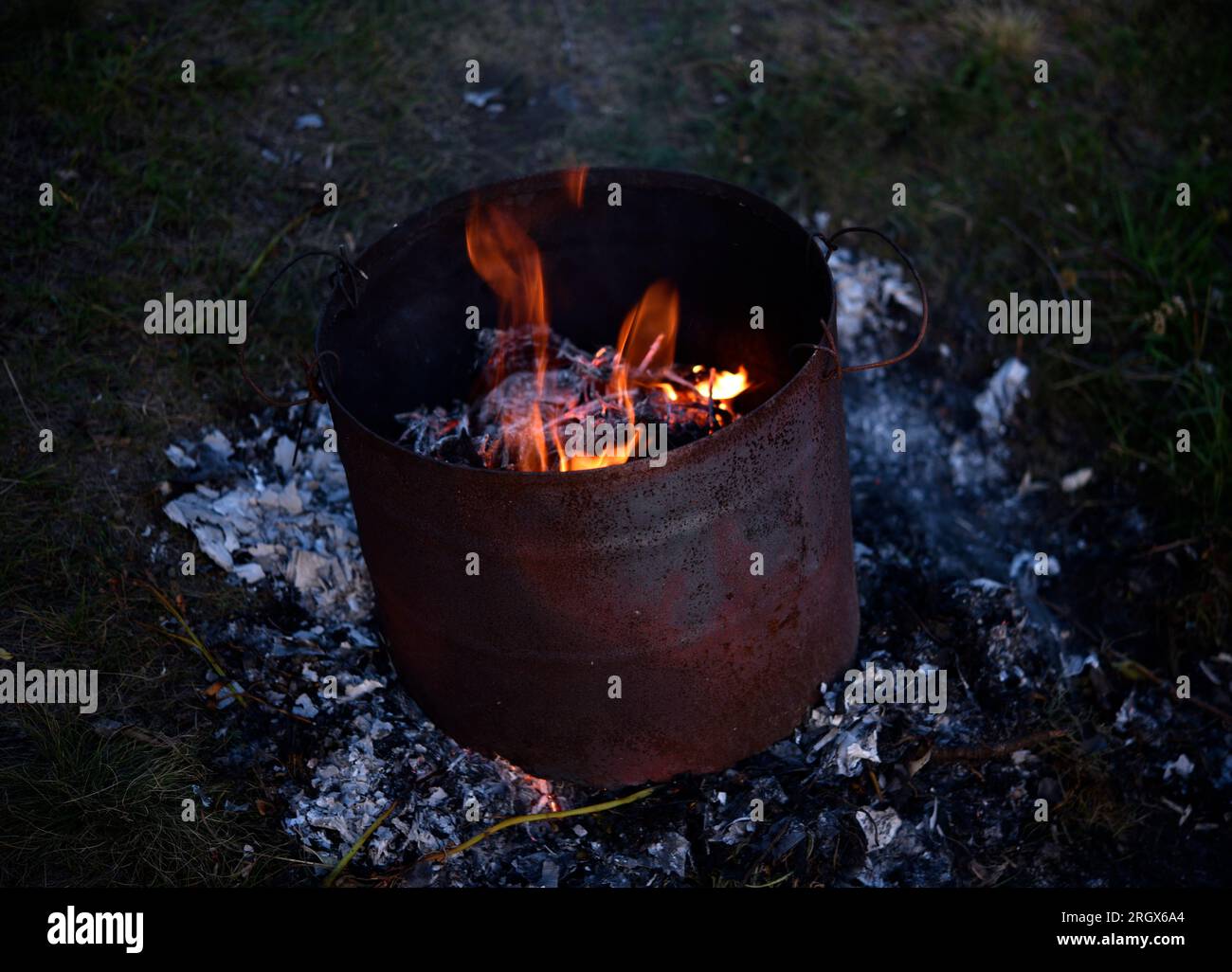 Burning garbage in the tank. Incineration of garbage in an iron bucket ...