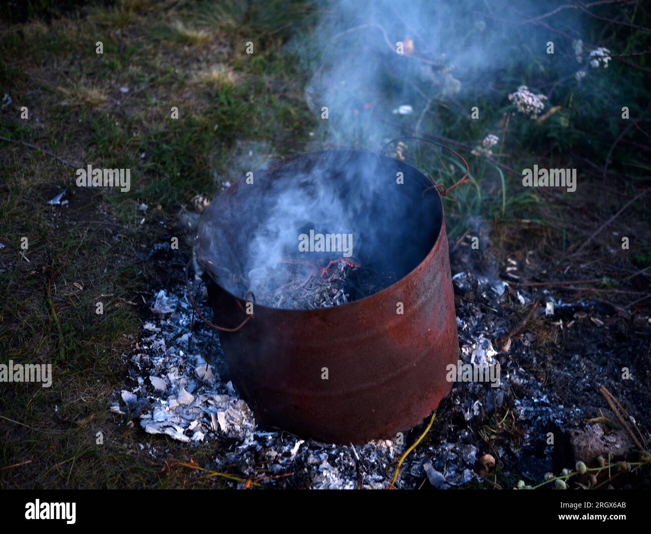 Burning garbage in the tank. Incineration of garbage in an iron bucket ...