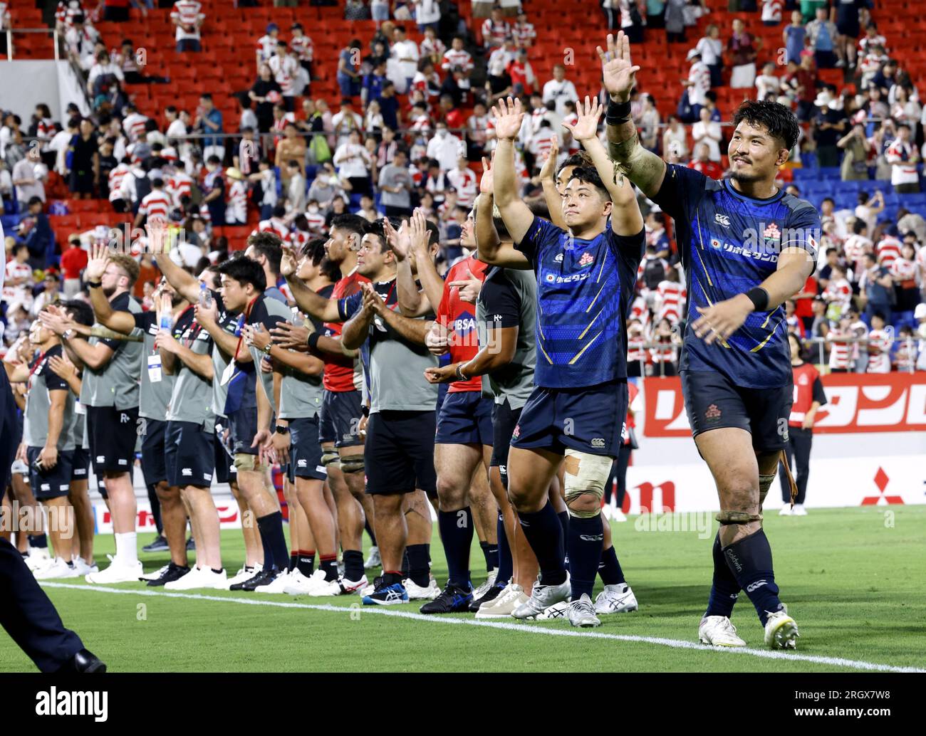 Japan players wave to the crowd following the team's 21-16 win over ...